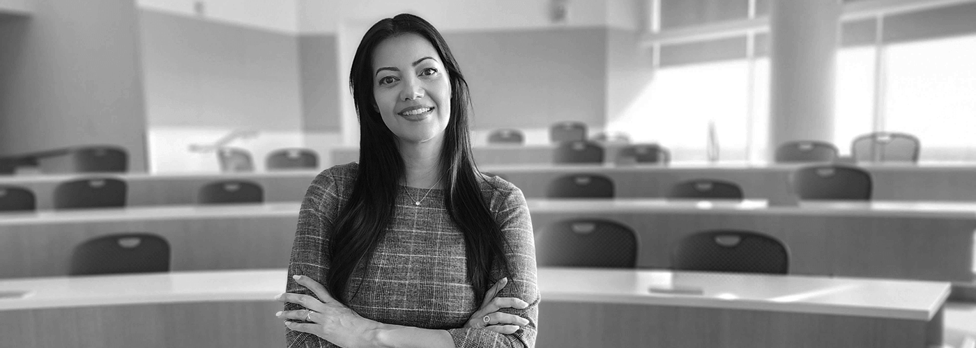 Photo of Elaine Costa standing in front of a classroom.
